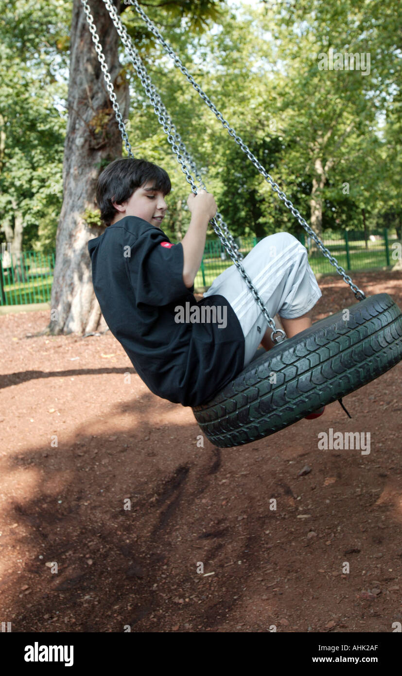 Boy swinging on rope tyre hi-res stock photography and images - Alamy