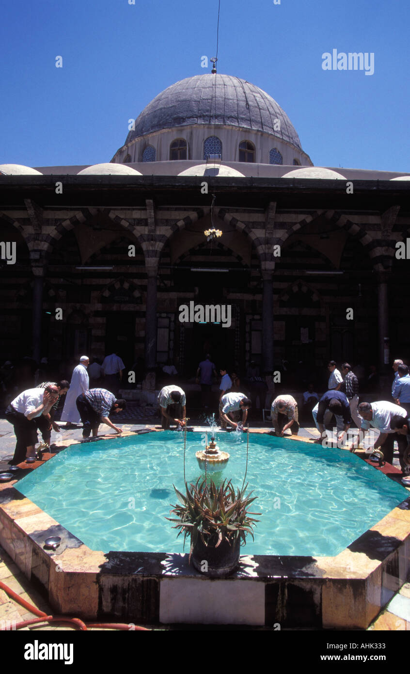Muslims in courtyard of mosque washing hands and feet prior to entering ...