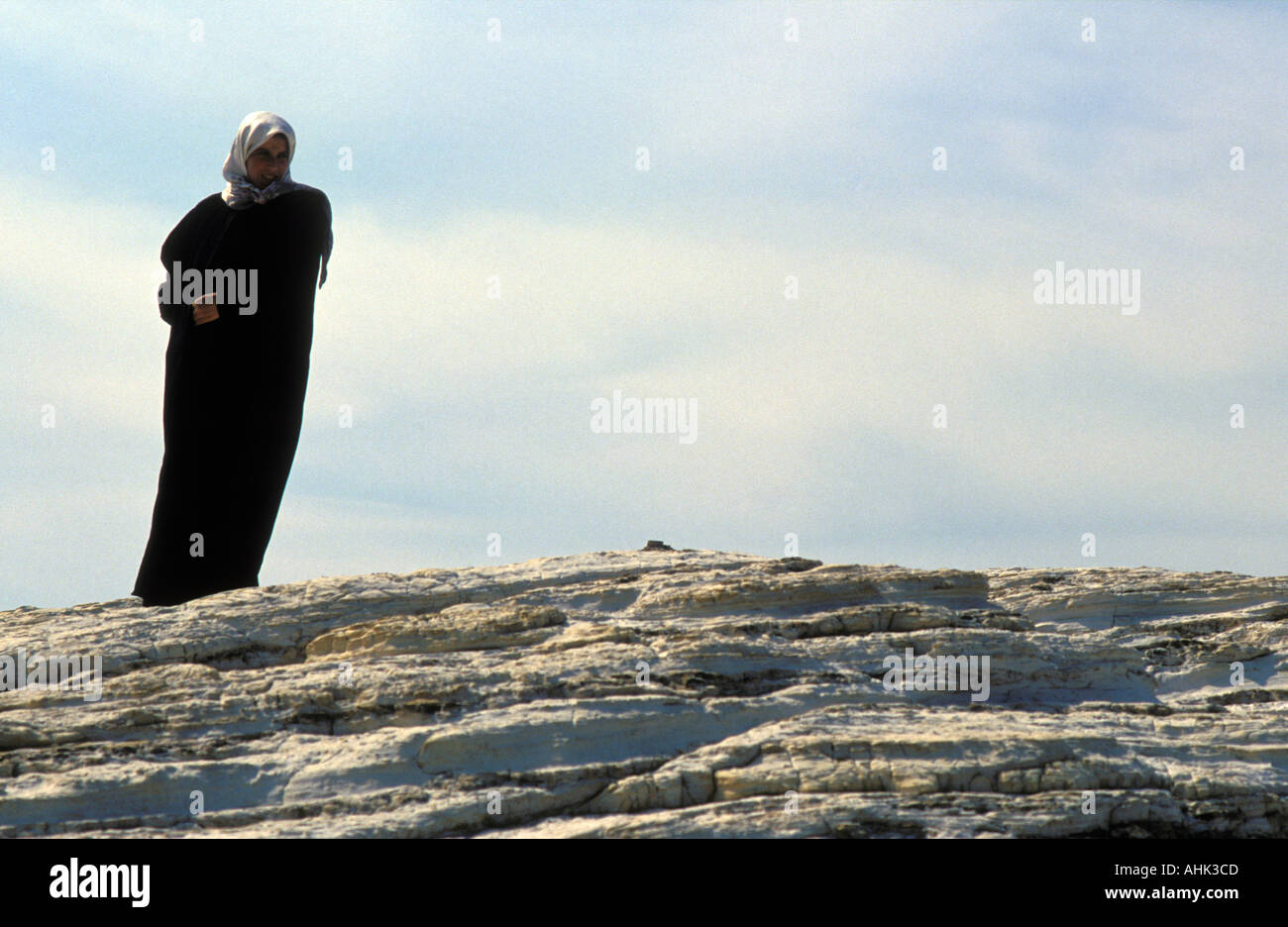 Shia Lebanese woman standing on rock formation by coast, Beirut ...
