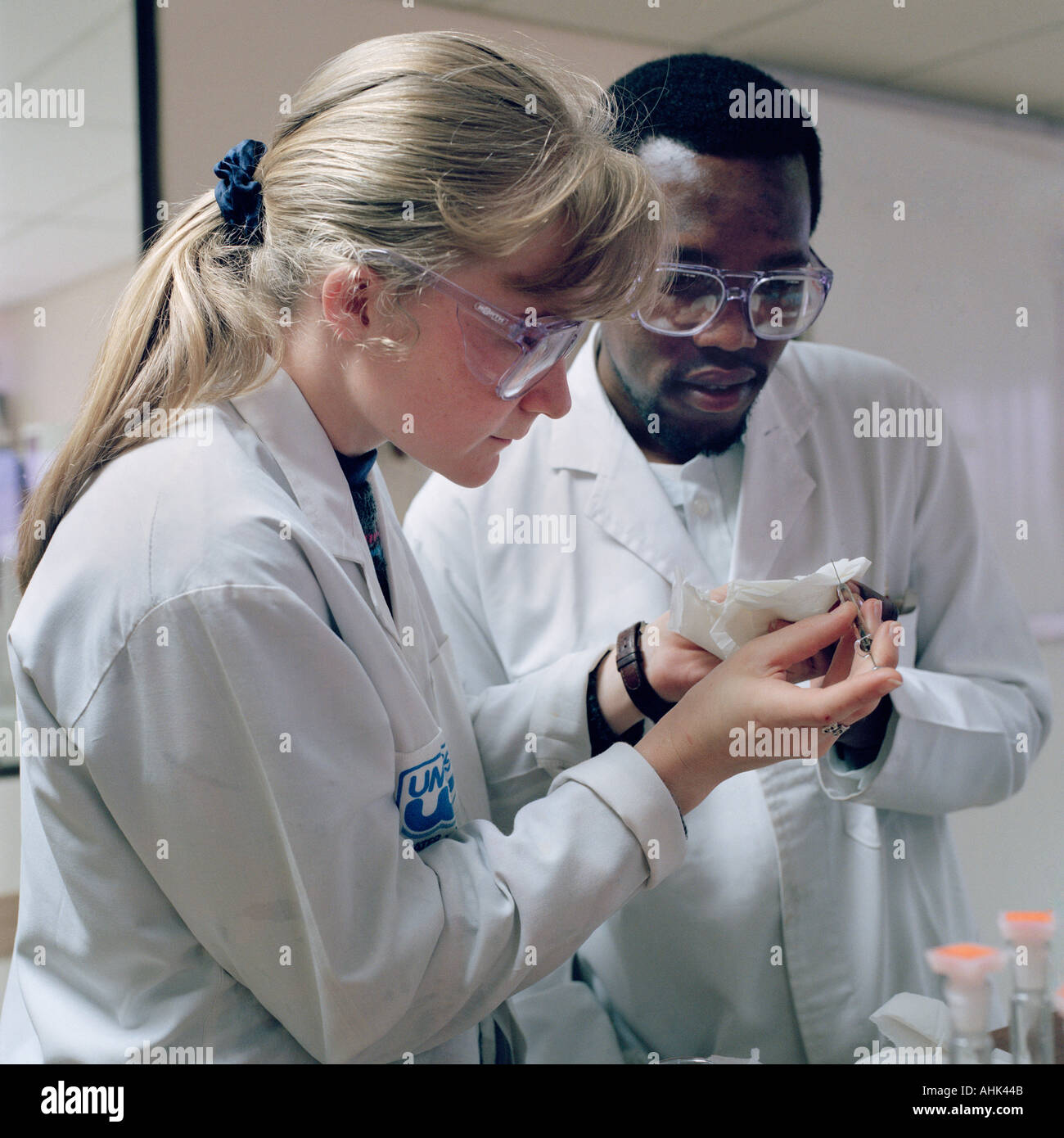 Female and male laboratory technicians monitoring water quality samples ...