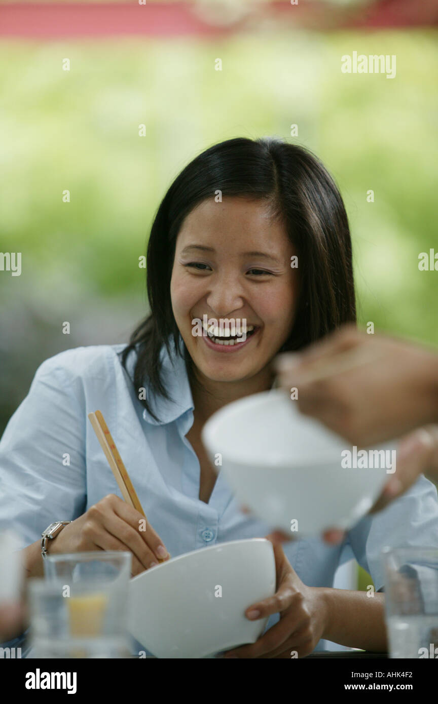 Asian woman eating using chopsticks bowl dinner party lunch friends ...