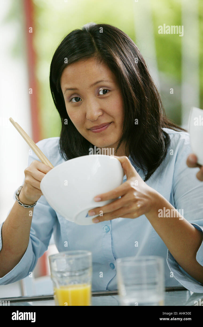 Asian woman eating using chopsticks Stock Photo - Alamy