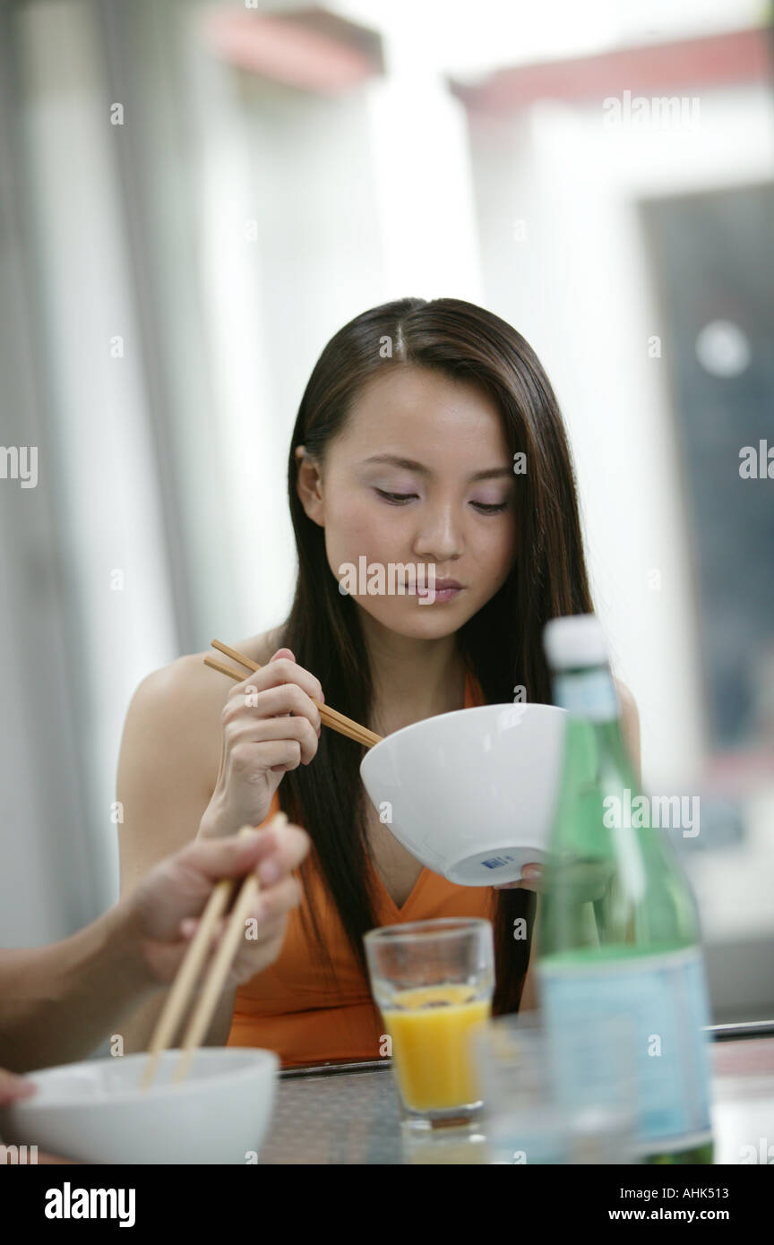 Asian woman eating using chopsticks Stock Photo - Alamy