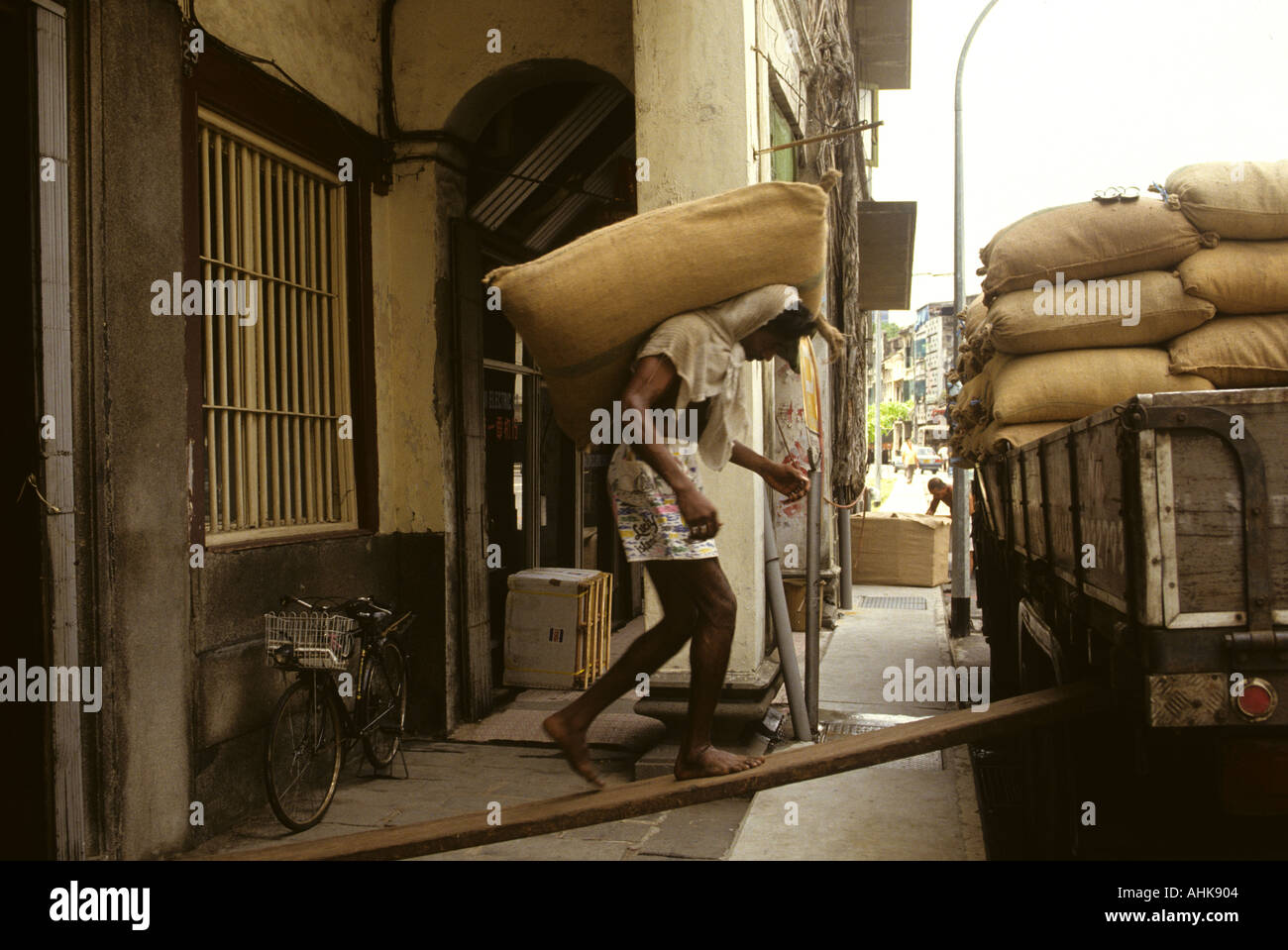 Singapore Man loads heavy sacks Stock Photo - Alamy