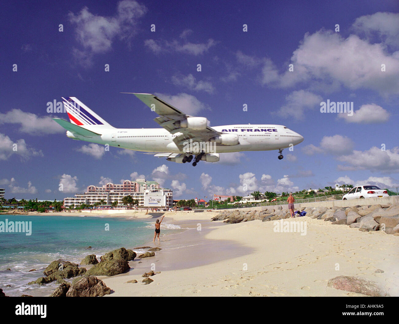 747 air France landing over a beach with people on the beach standing ...