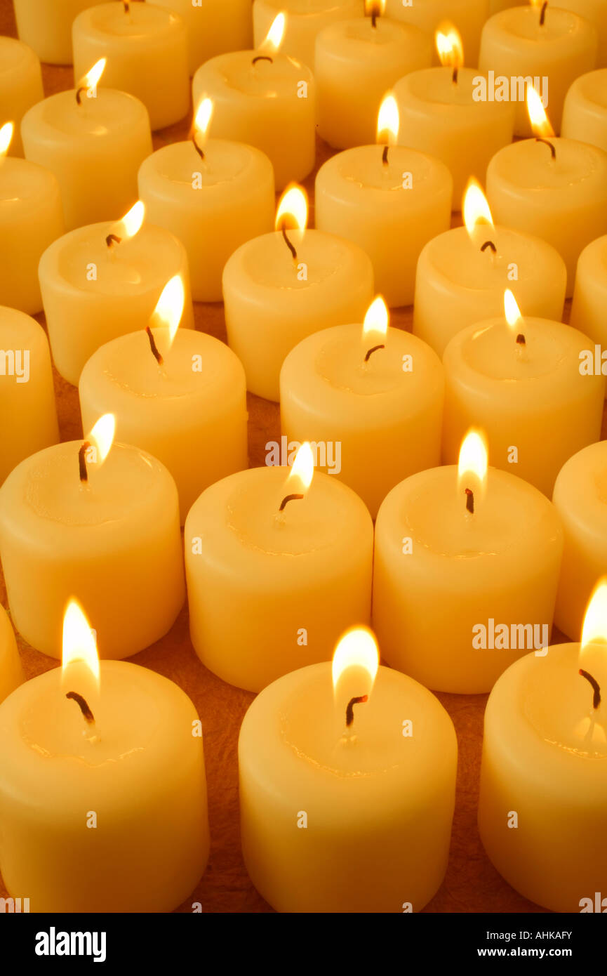 A large number of lit yellow candles Stock Photo - Alamy