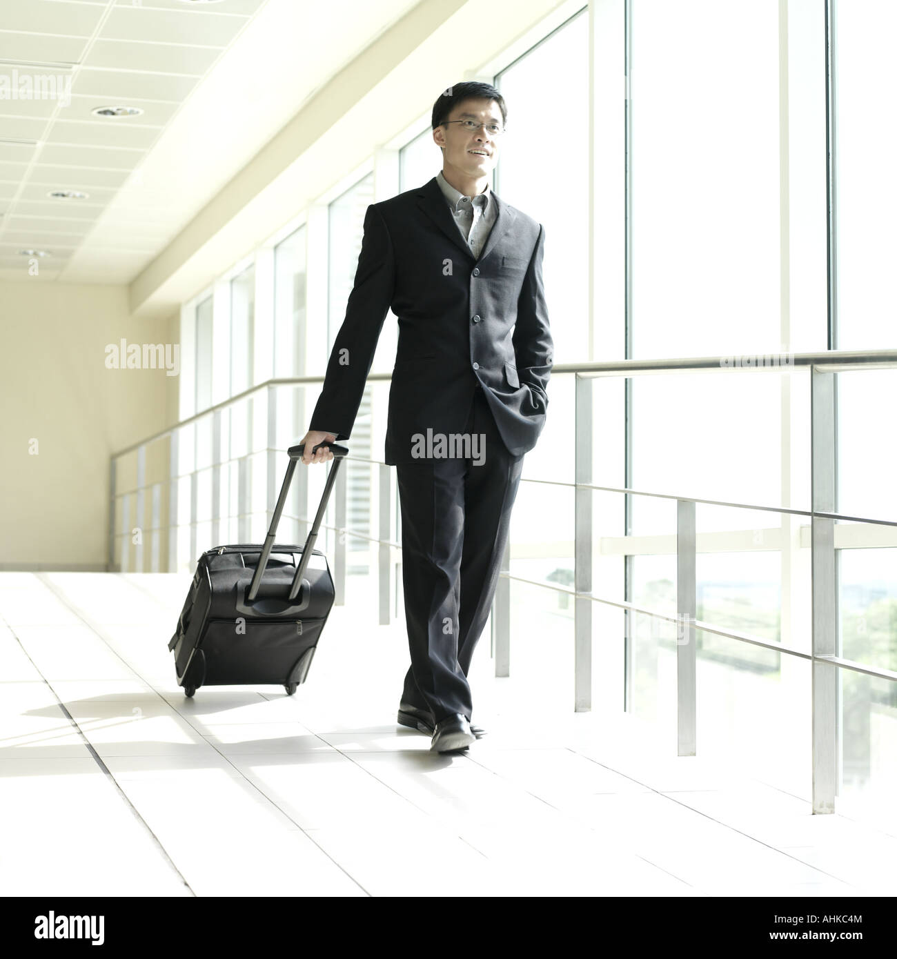 Businessman pulling his luggage Stock Photo - Alamy