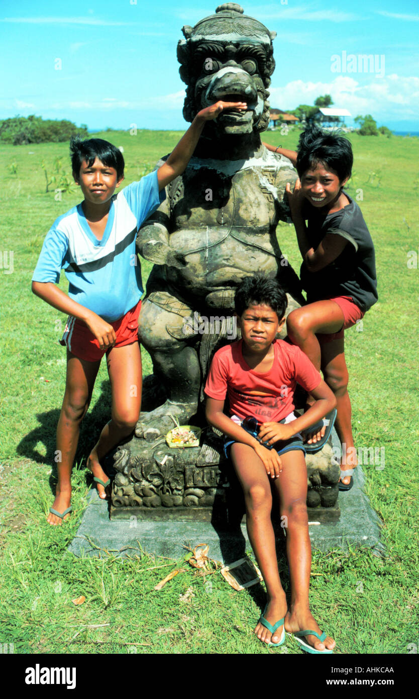 YOUNG BOYS BY STONE STATUE Bali Indonisia Stock Photo - Alamy