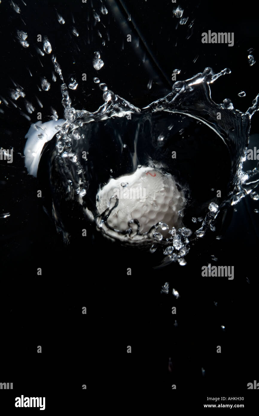 White golf ball splashing into water Stock Photo - Alamy