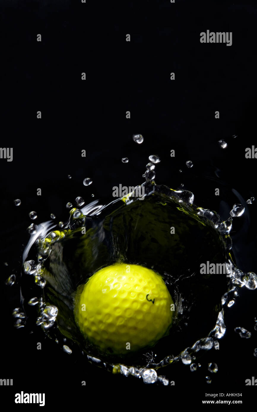 Yellow golf ball splashing into water Stock Photo - Alamy