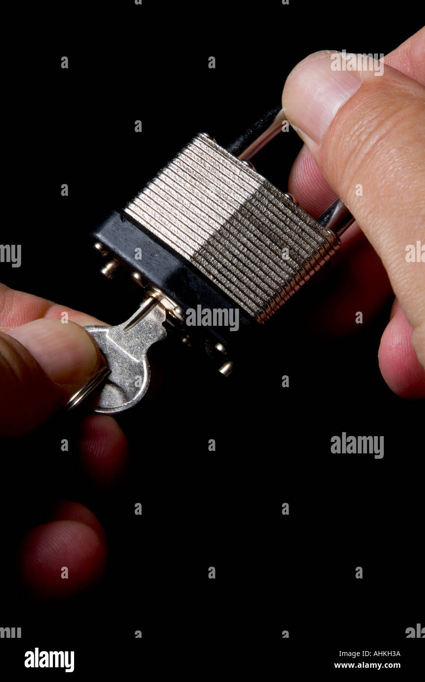 Hands unlocking padlock with keys Stock Photo - Alamy