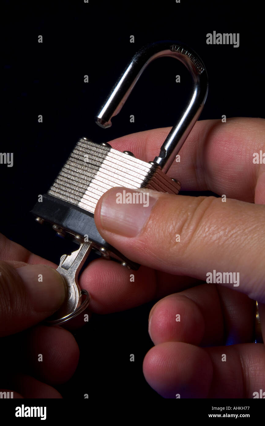 Hands unlocking padlock with keys Stock Photo - Alamy