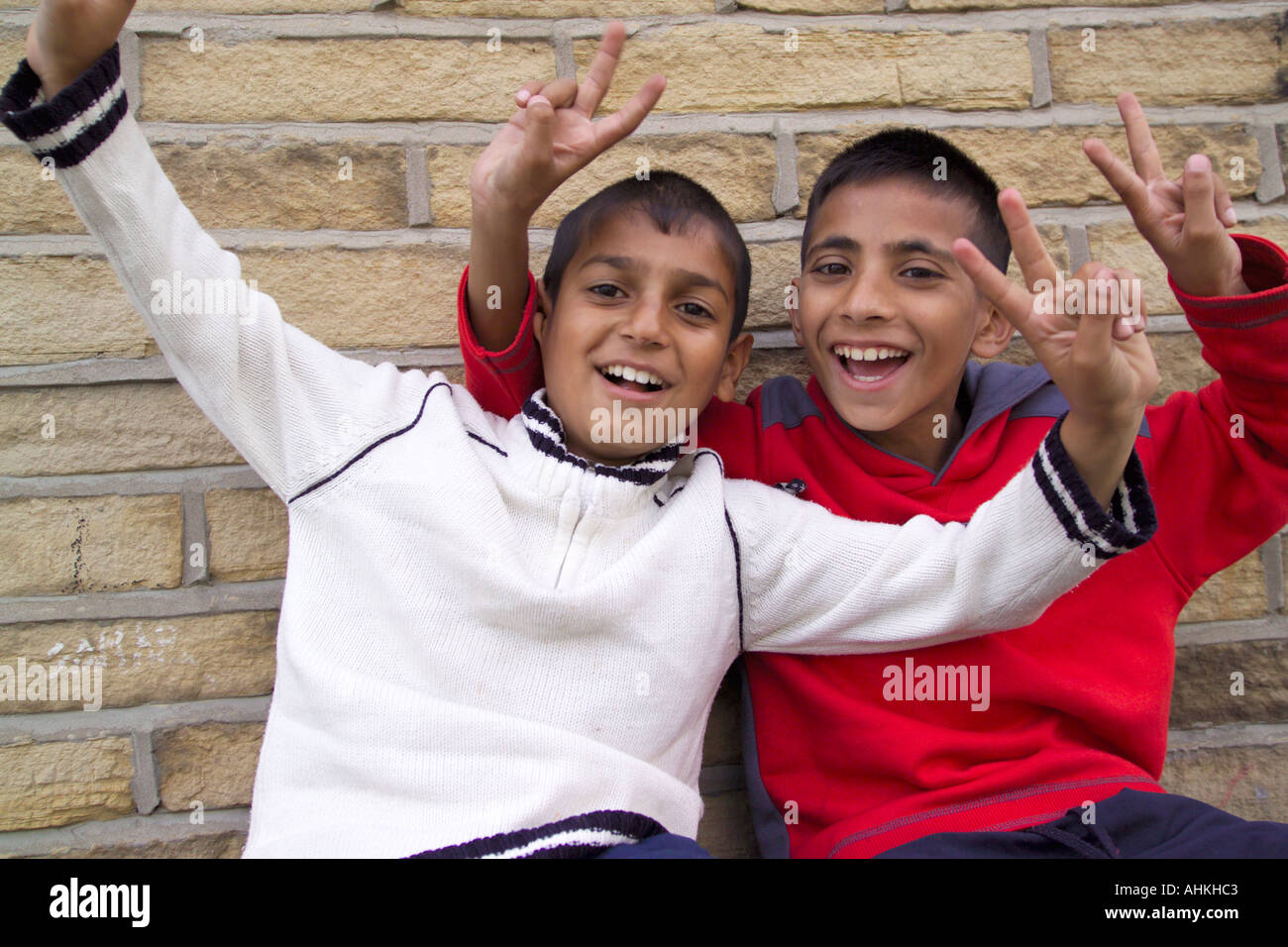Two smiling happy Asian boys on a street corner Laisterdyke Bradford ...