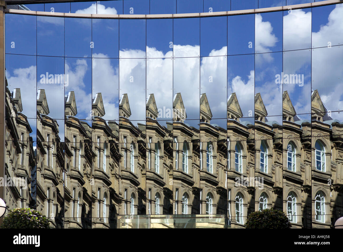 Reflections of old buildings in mirrored glass covered modern building ...
