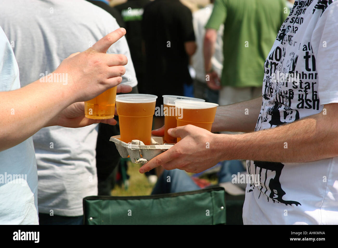 Several pints of British bitter beer in a plastic glass used for safety ...