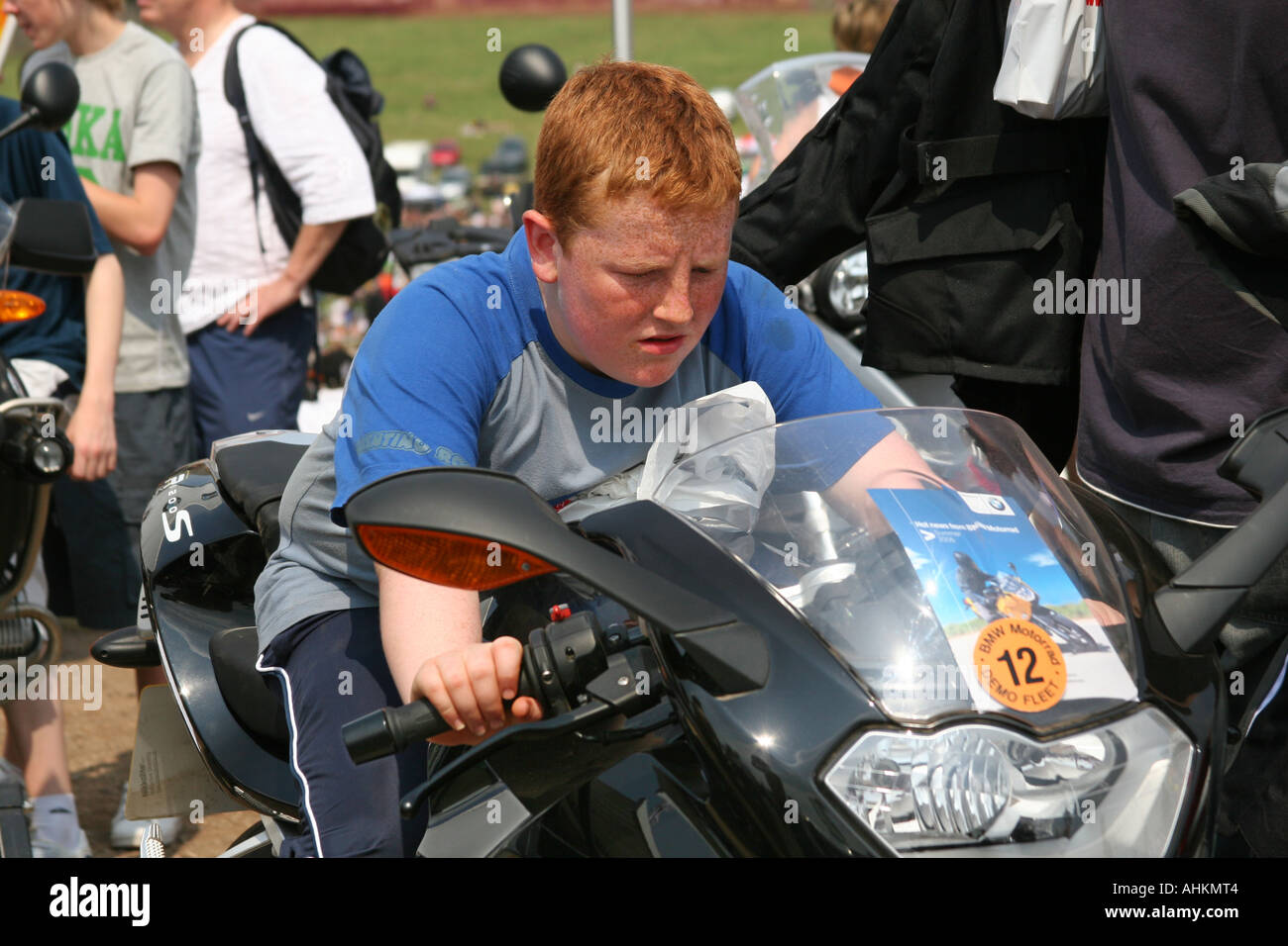 Young red headed boy sitting on new motorcycle at Donnington Park race ...