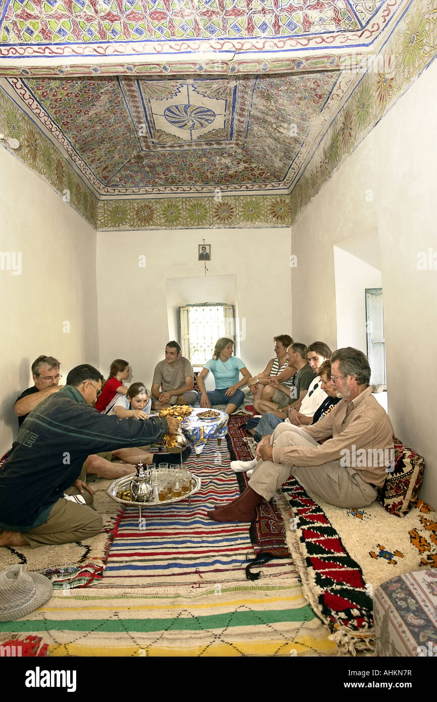 Moroccan man serving tea to foreign guests in a local house of Agouti ...