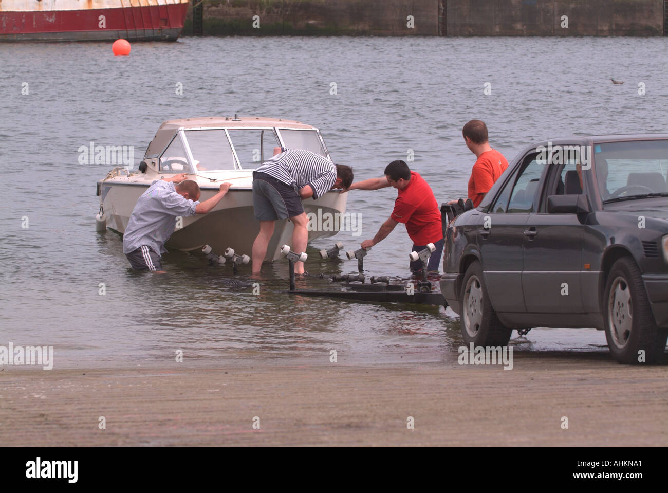 men taking motor boat out of water at a launch in dingle harbour county ...