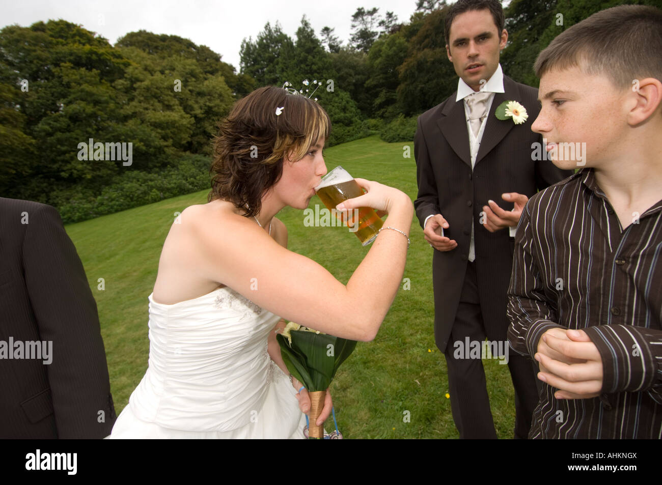 bride drinking a pint of beer at her wedding reception in between ...