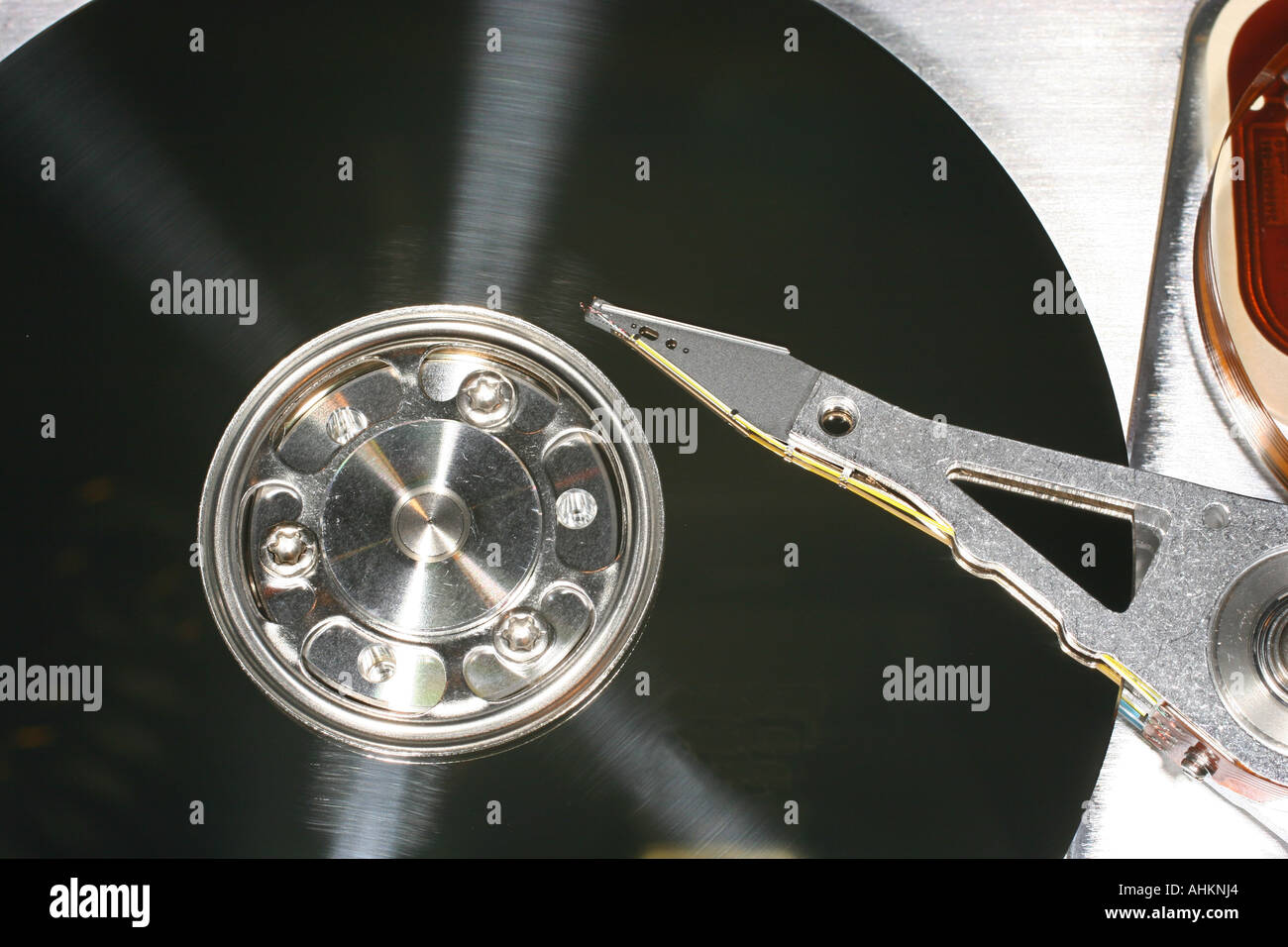 Close shot of surface of computer hard disk with magnetic reading arm ...