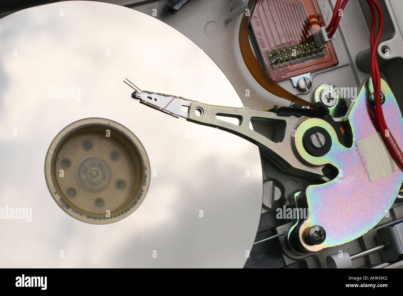 Close shot of surface of computer hard disk with magnetic reading arm ...