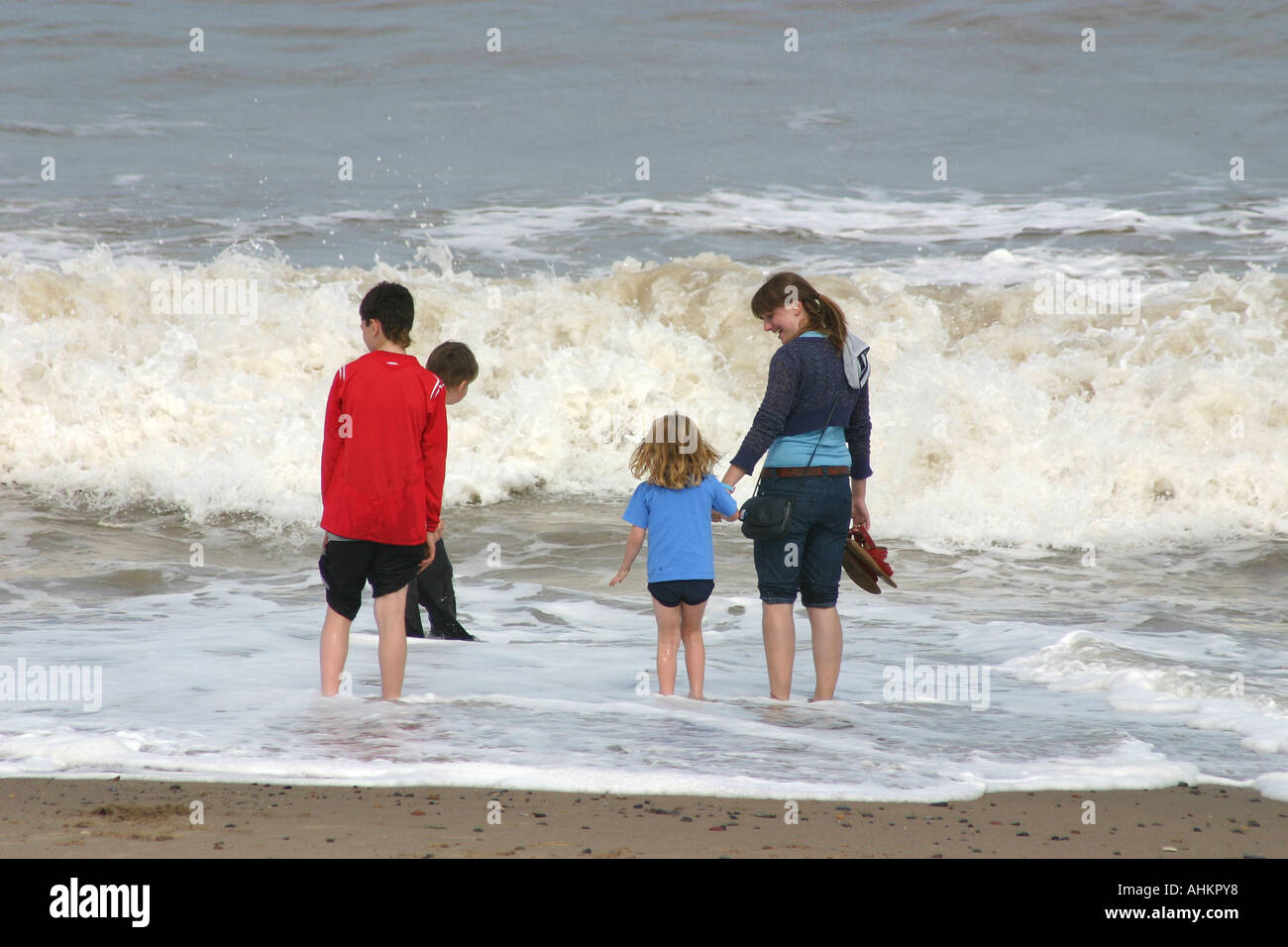 kids playing in waves at seaside Stock Photo - Alamy