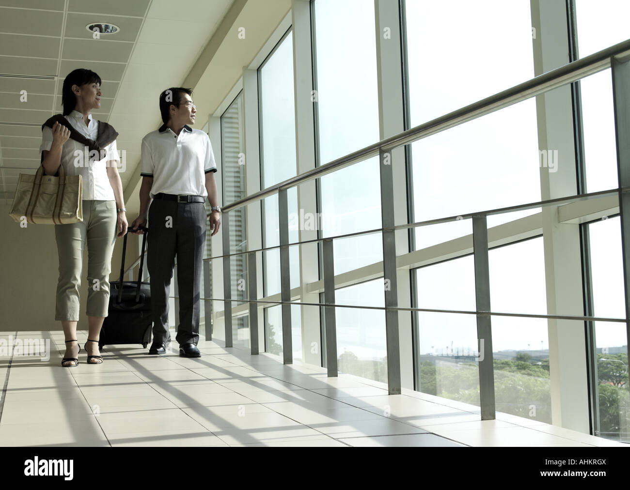 Couple walking down corridor Stock Photo - Alamy