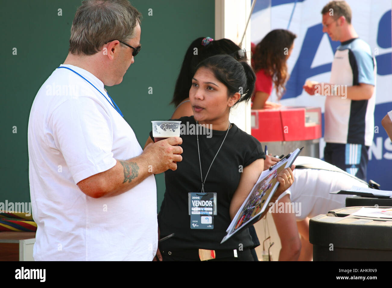 Girl at show attempting to interest passer by in the product of her ...