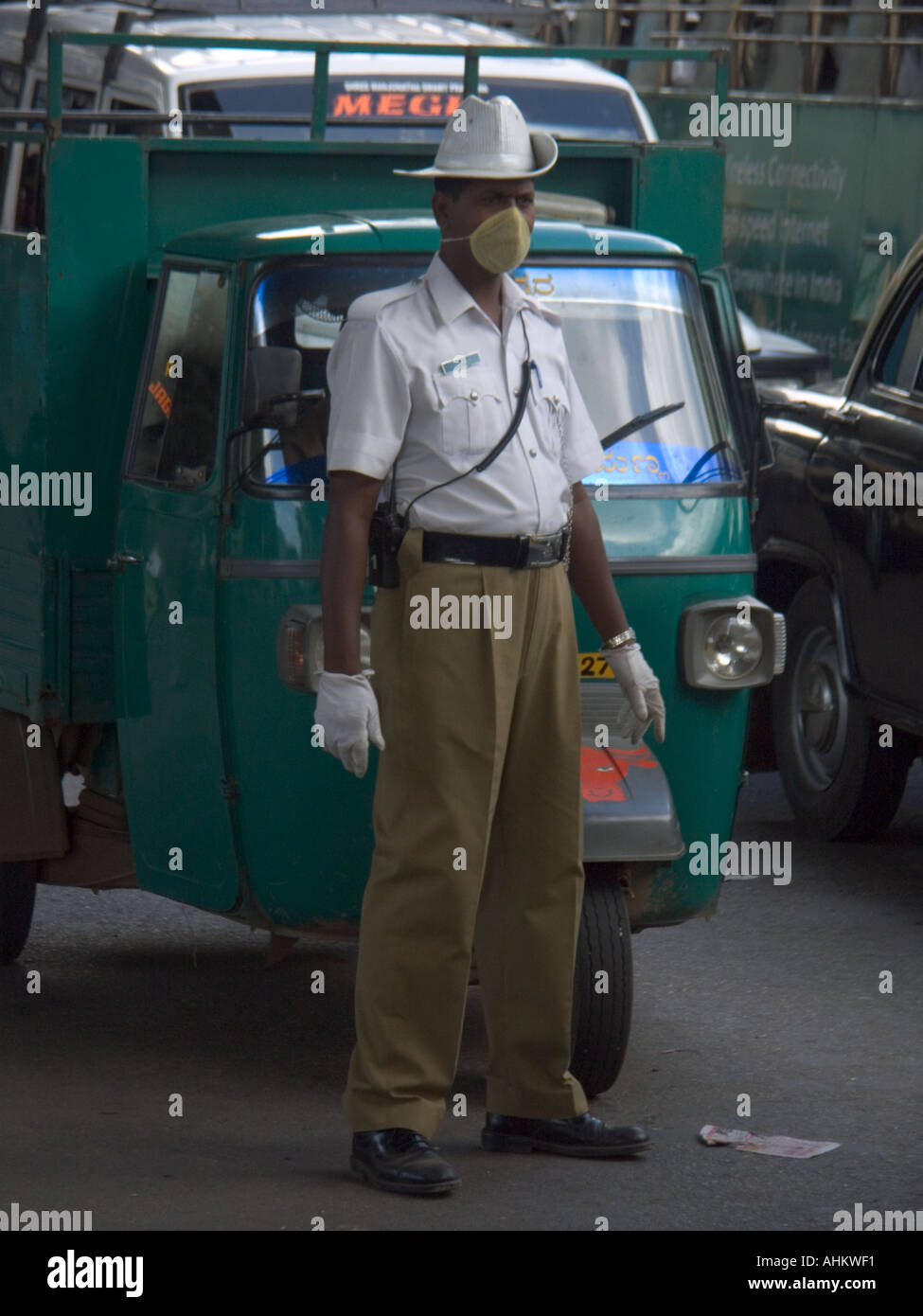 Traffic cop with dust mask to keep out vehicle pollutants, directing ...