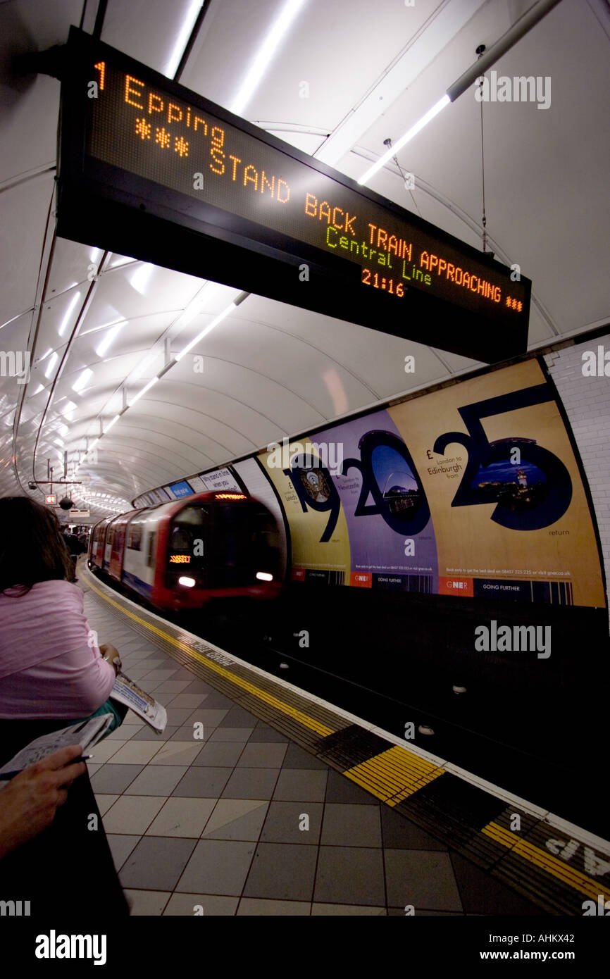 commuters on platform with indicator board waiting for london ...