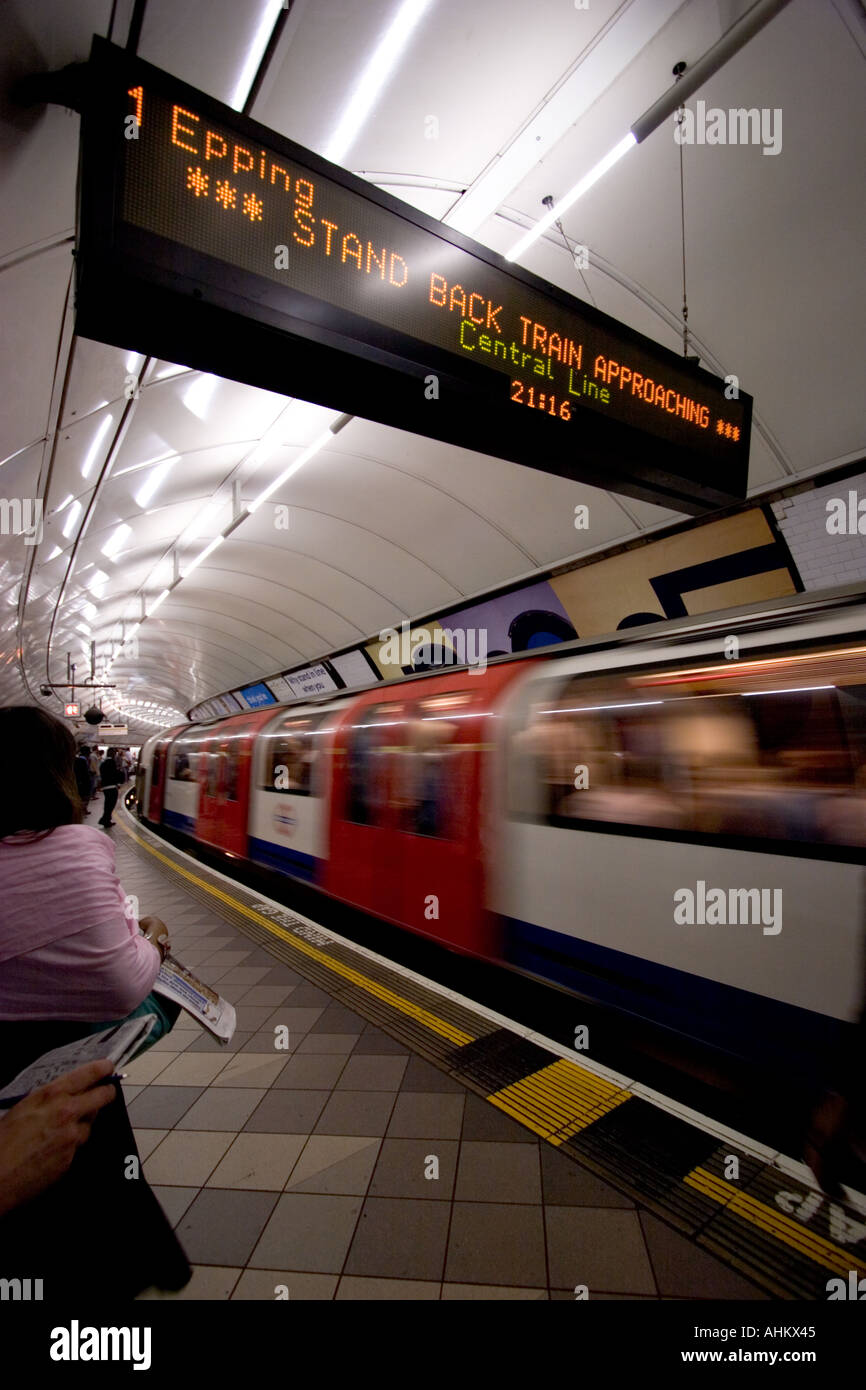 commuters on platform with indicator board waiting for london ...