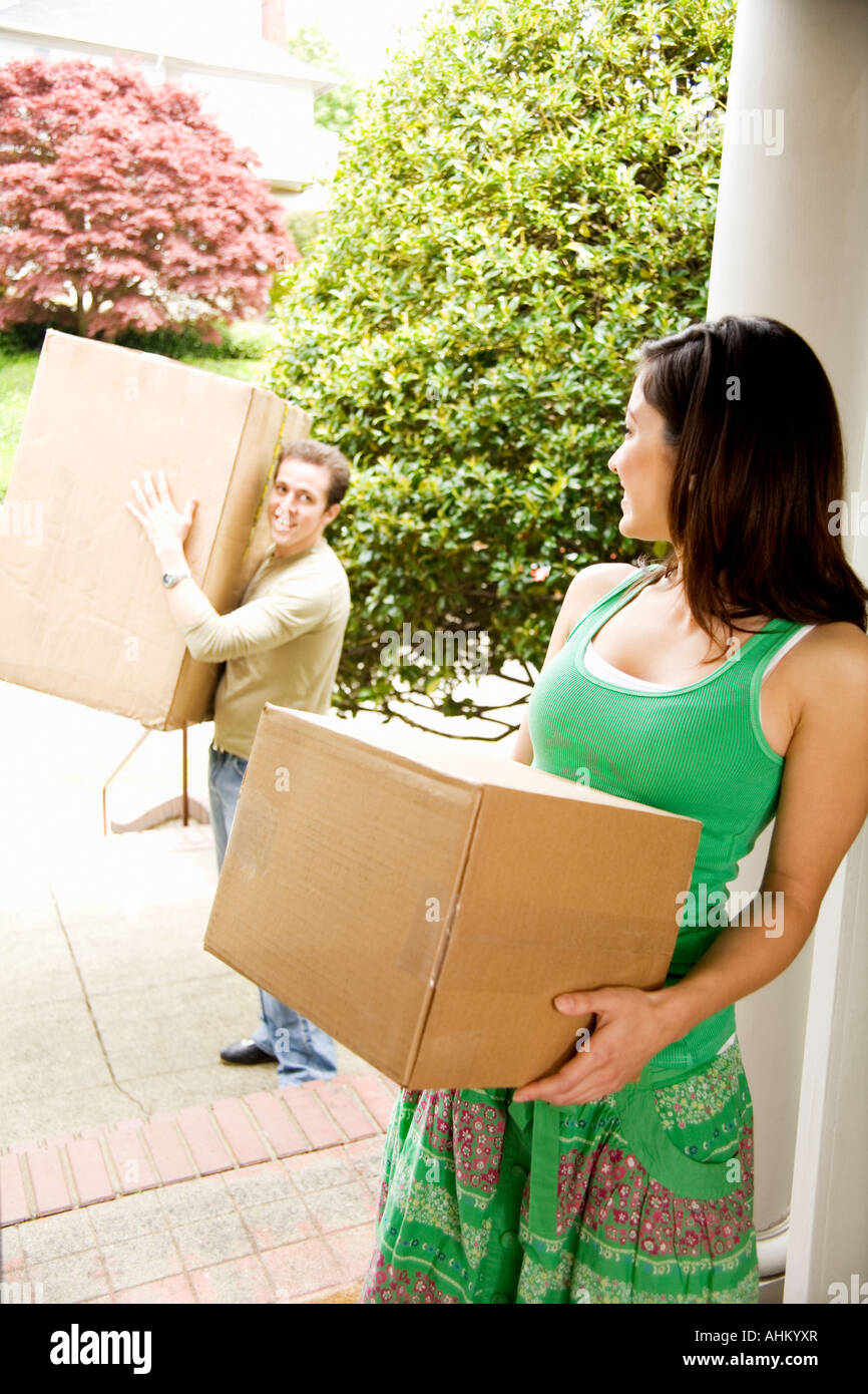 Couple carrying moving boxes Stock Photo - Alamy