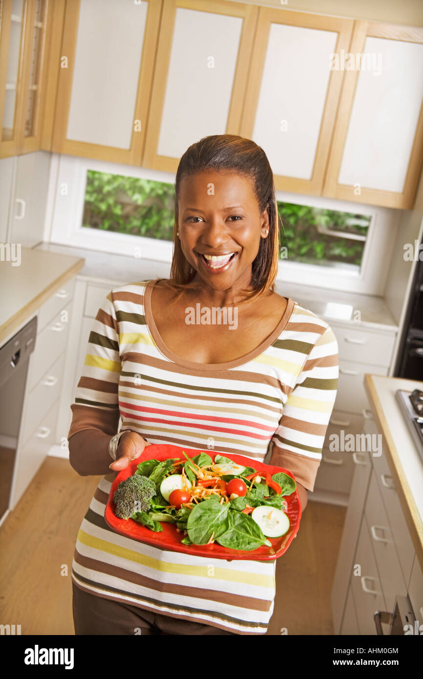 African woman holding plate of vegetables Stock Photo - Alamy