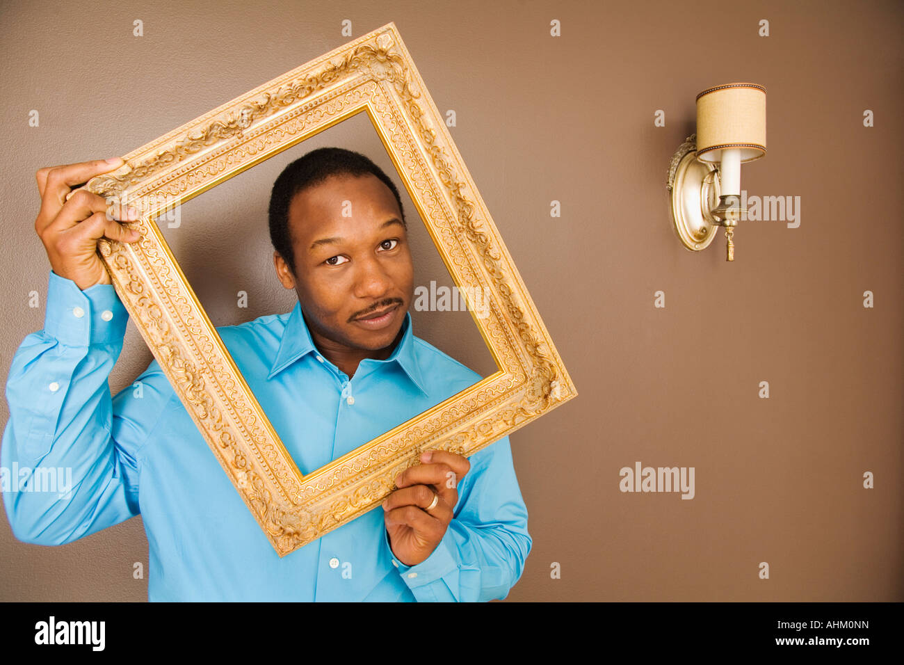 African man looking through picture frame Stock Photo - Alamy