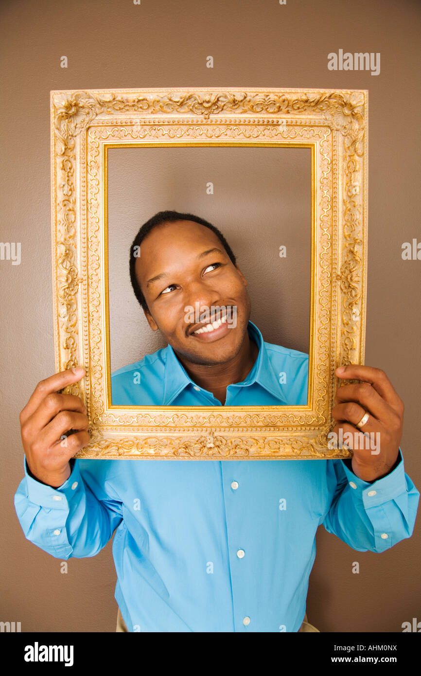African man looking through picture frame Stock Photo - Alamy