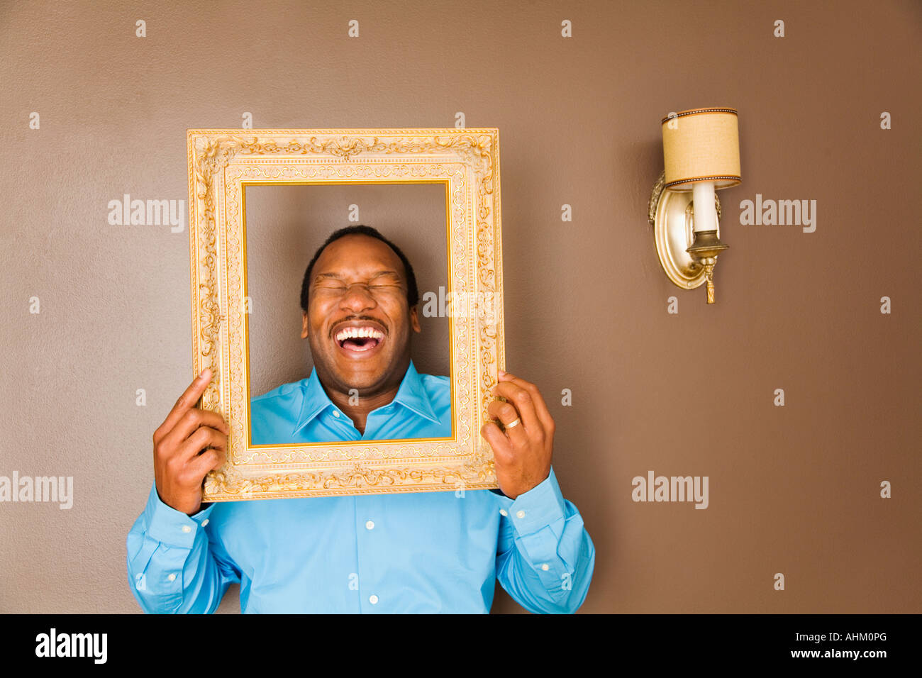 African man looking through picture frame Stock Photo - Alamy