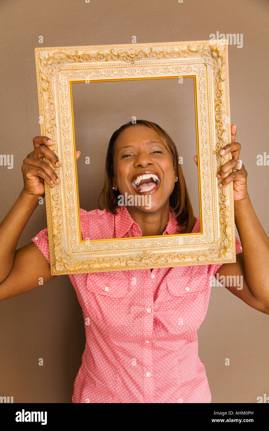 African woman looking through picture frame Stock Photo - Alamy