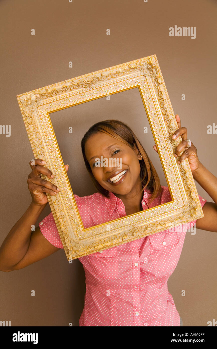 African woman looking through picture frame Stock Photo - Alamy