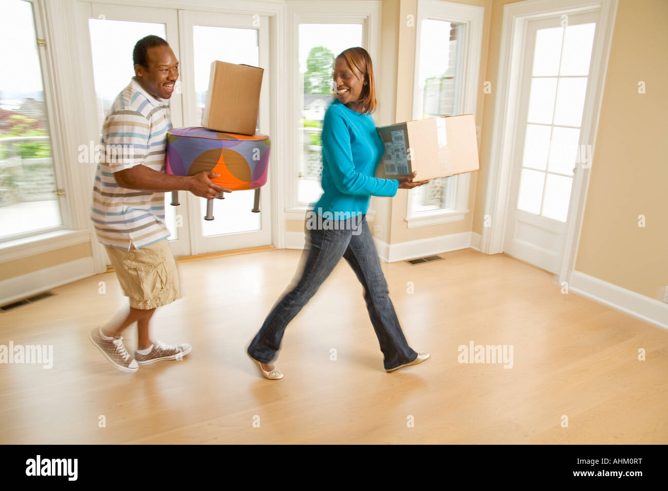 African couple carrying moving boxes Stock Photo - Alamy