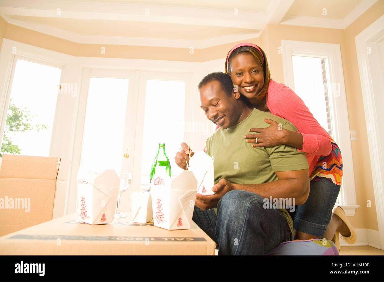 African couple eating take out in new house Stock Photo - Alamy