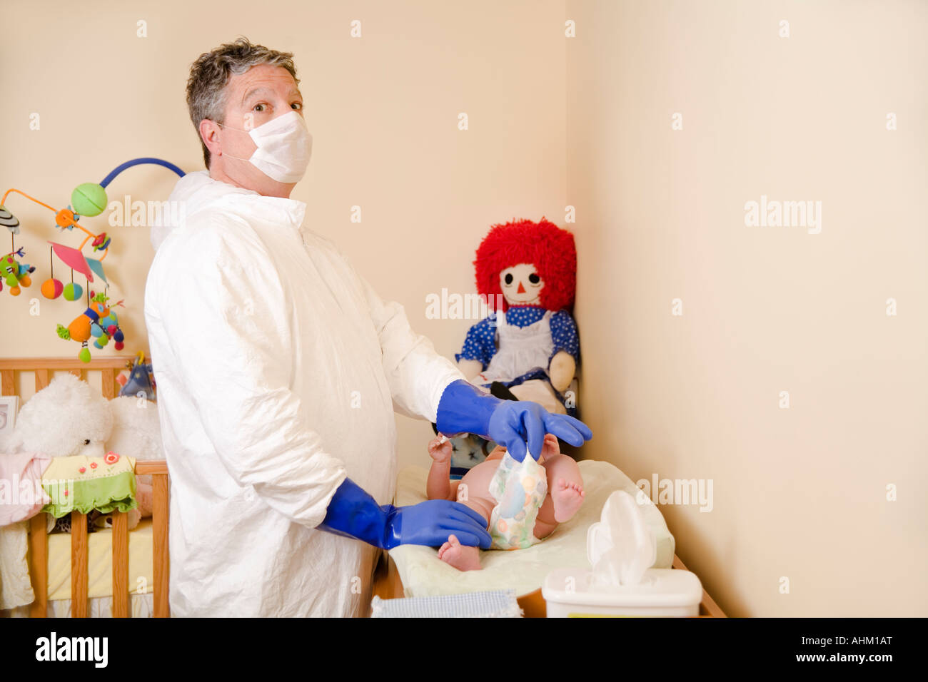 Father in decontamination suit changing baby’s diaper Stock Photo - Alamy