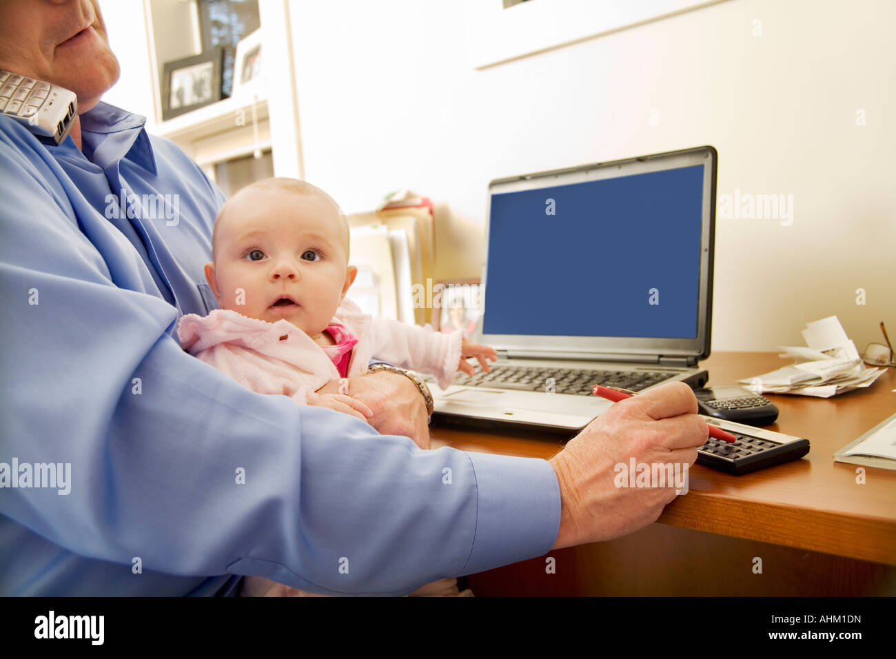 Businessman working with baby on lap Stock Photo - Alamy