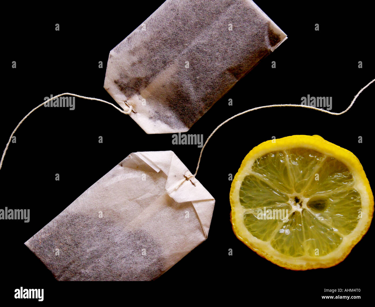 Teabags and a slice of lemon against a black background Stock Photo - Alamy