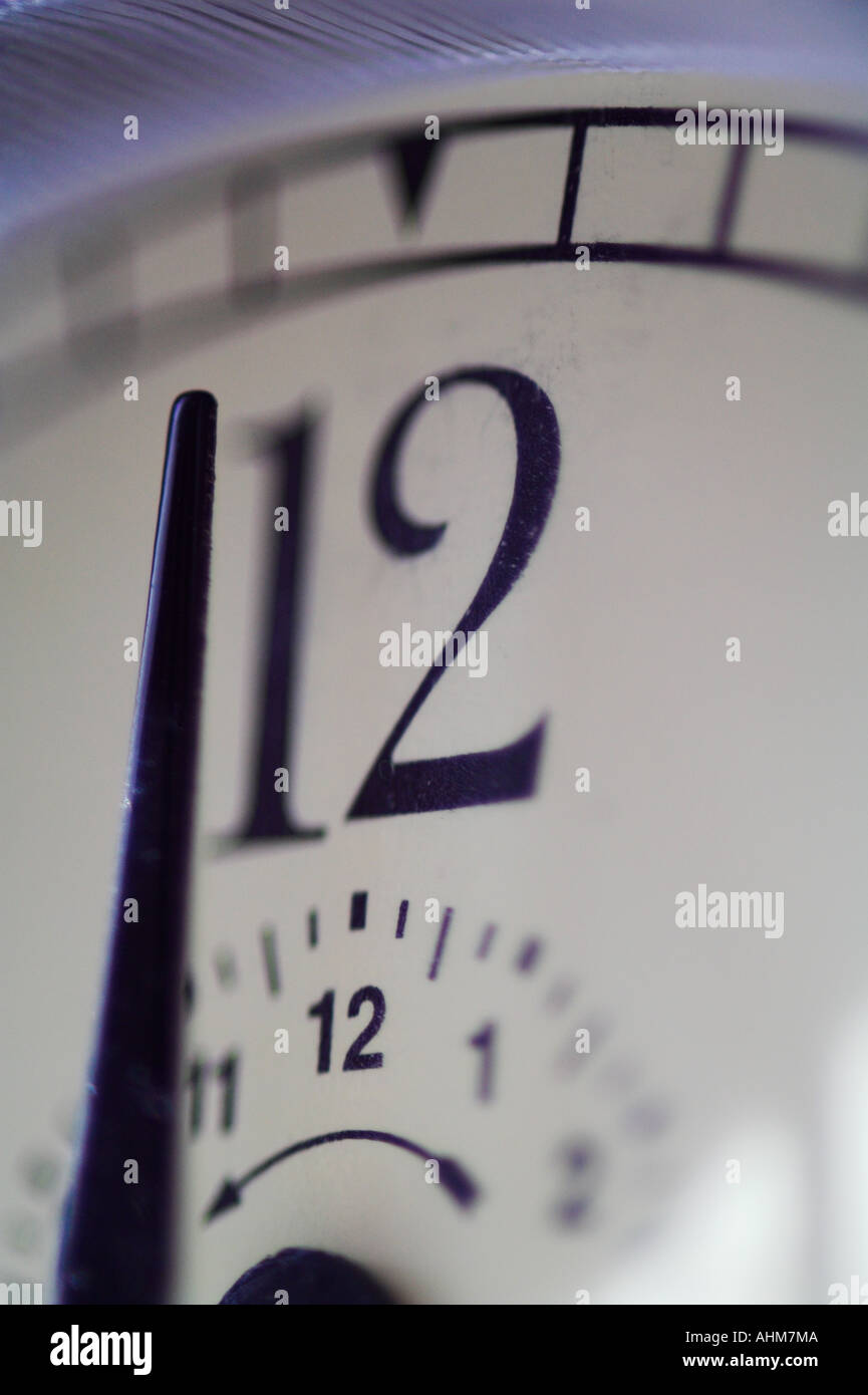 Close-up of clock with hands near 12 o'clock with sun light on the ...
