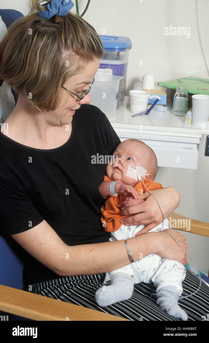 young mum holding her premature baby in special care baby unit of ...