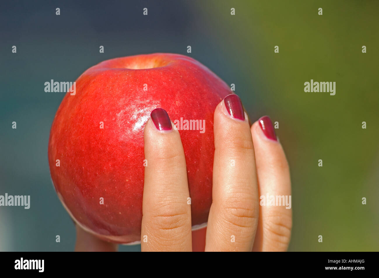 Fingers holding red apple Stock Photo - Alamy