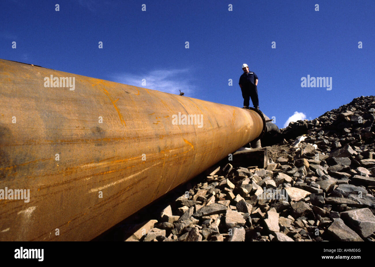Industry man standing on large pipe Stock Photo - Alamy