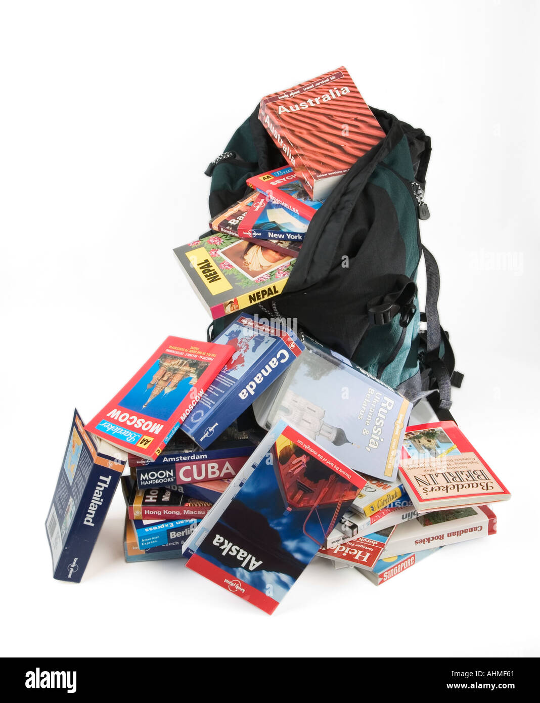 Rucksack overflowing with travel guide books against white background ...