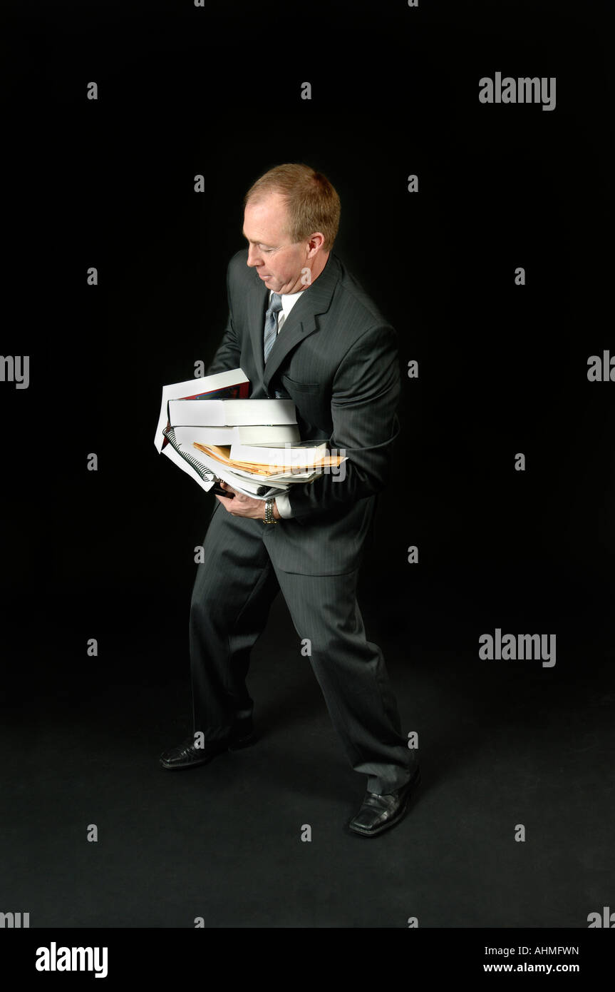 Man overloaded with books / papers / work Stock Photo - Alamy
