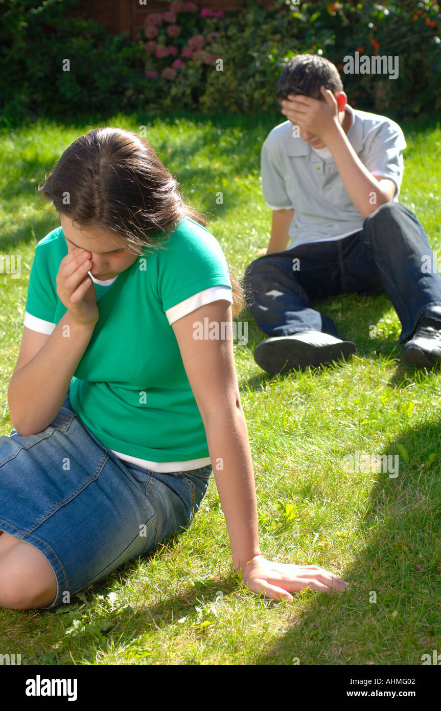 teenage couple sitting together in the park having an argument and ...